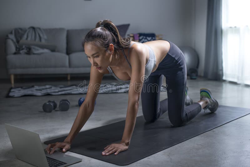 Training at Home Concept. Sporty Asian Woman Doing Exercise while Watching Online Tutorial on ...