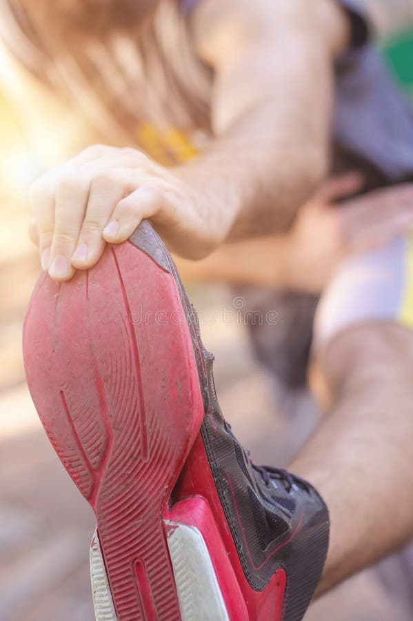 Training Outdoors. Young Man Stretching His Legs. Stock Photo - Image ...