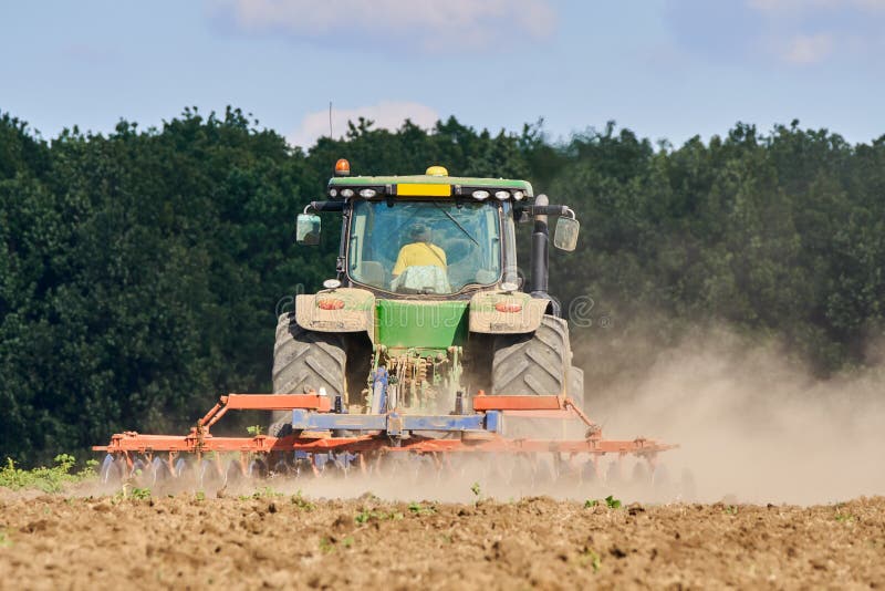 Traktor, der das Feld eggt redaktionelles bild. Bild von land - 100199185
