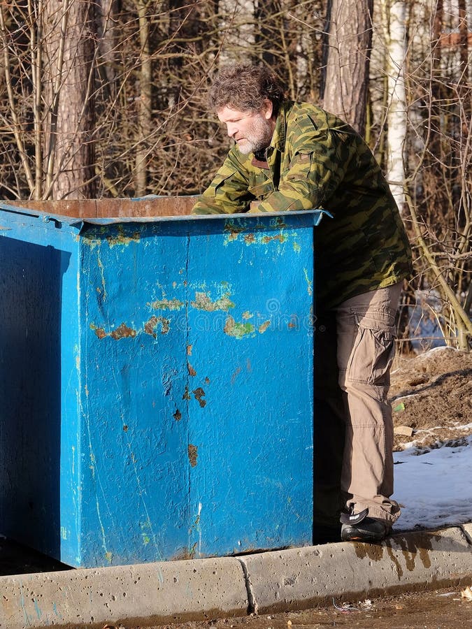 Tramp near the garbage bin stock photo. Image of beggar - 68346430