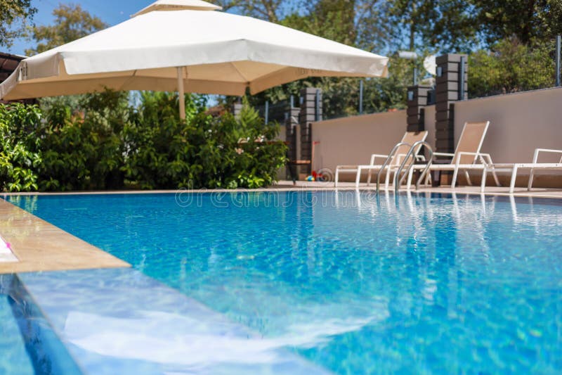 Refreshing Poolside Oasis with Lounge Chairs and an Umbrella in a Sunny ...