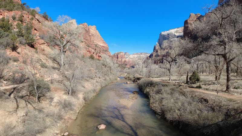 Tranquil Stream Flowing through a Canyon with Towering, Sandy-colored ...