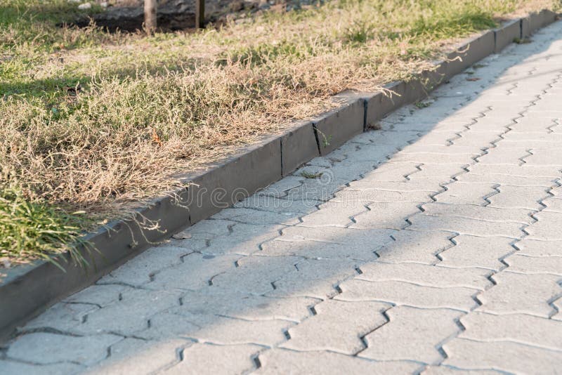 Tranquil Urban Pathway with Lush Grass and Paved Stones Stock Photo ...
