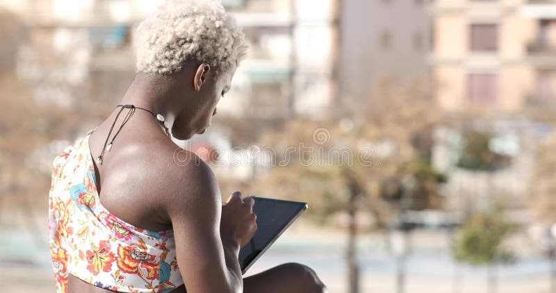 Transgender Person Using a Digital Tablet Sitting Outdoors. Stock ...