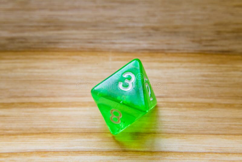A Translucent Green Eight Sided Playing Dice on a Wooden Background ...