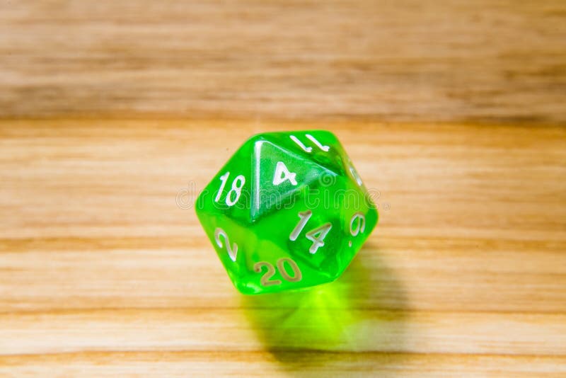A Translucent Green Twenty Sided Playing Dice on a Wooden Background ...