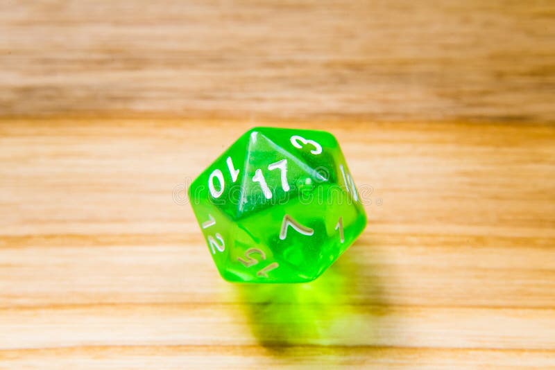 A Translucent Green Twenty Sided Playing Dice on a Wooden Background ...