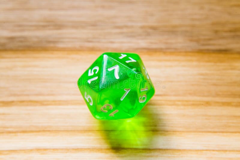 A Translucent Green Twenty Sided Playing Dice on a Wooden Background ...
