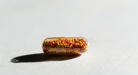 A Transparent Capsule Lies on a Light Surface, Casting a Shadow. Inside ...