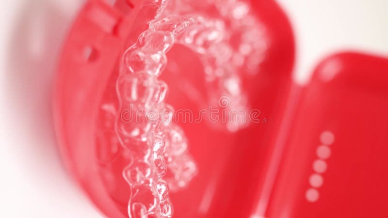 Invisalign Clear Aligner in Red Container Rotates Against Light Effects ...