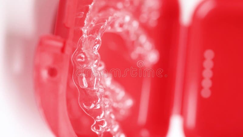 Invisalign Clear Aligner in Red Container Rotates Against Light Effects ...