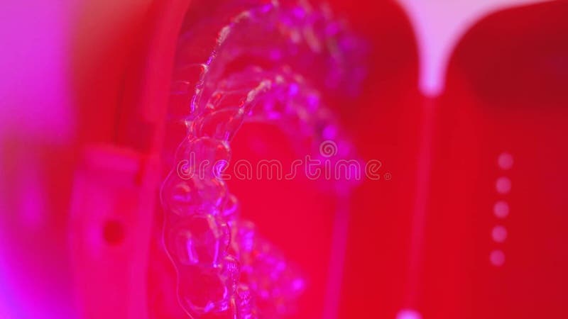 Invisalign Clear Aligner in Red Container Rotates Against Light Effects ...