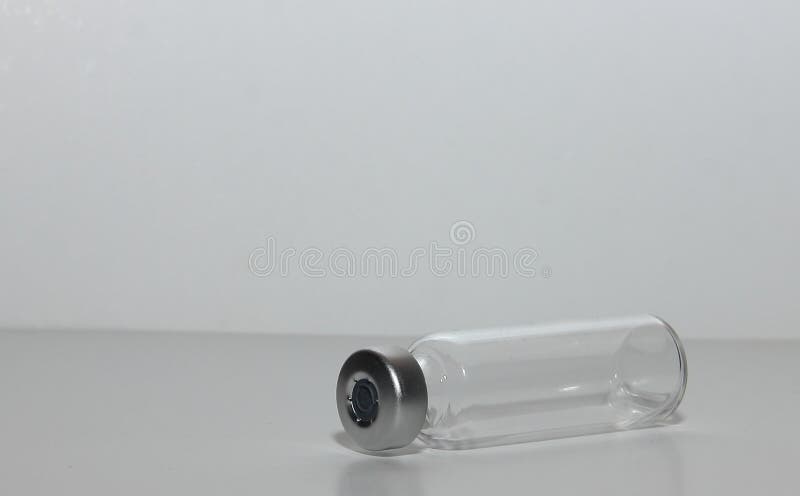 A Transparent Vial of Medication is on a White Flat Surface on the ...