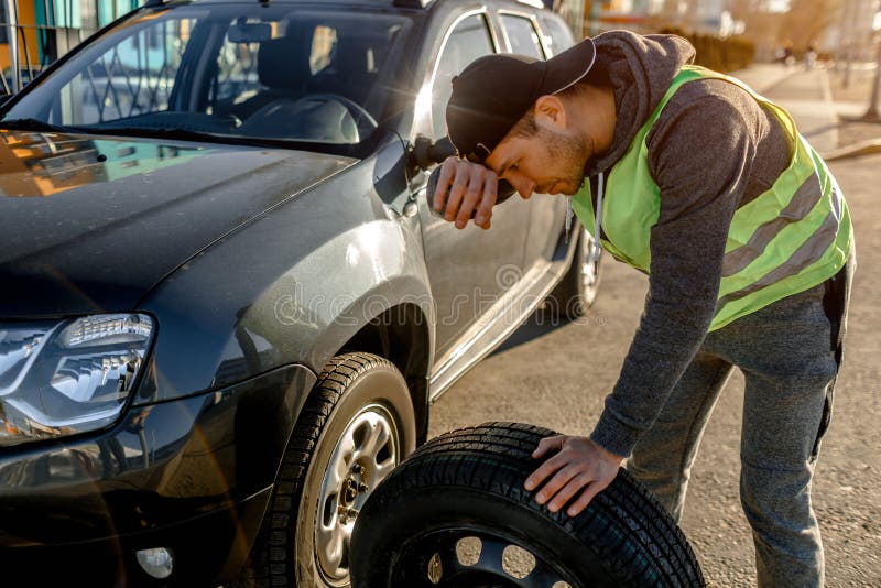 Transportation, Traveling Concept. Worker Changes a Broken Wheel of a ...
