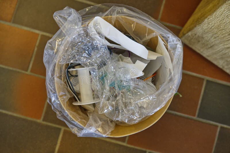 Overflowing Trash Bin Filled with Mixed Waste Including Plastic Spool ...