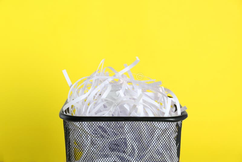 Trash Bin with Shredded Paper Strips on Yellow Background Stock Image ...