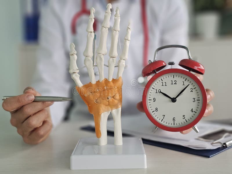 Traumatologist Shows a Sample of the Skeleton of the Hand and an Alarm ...