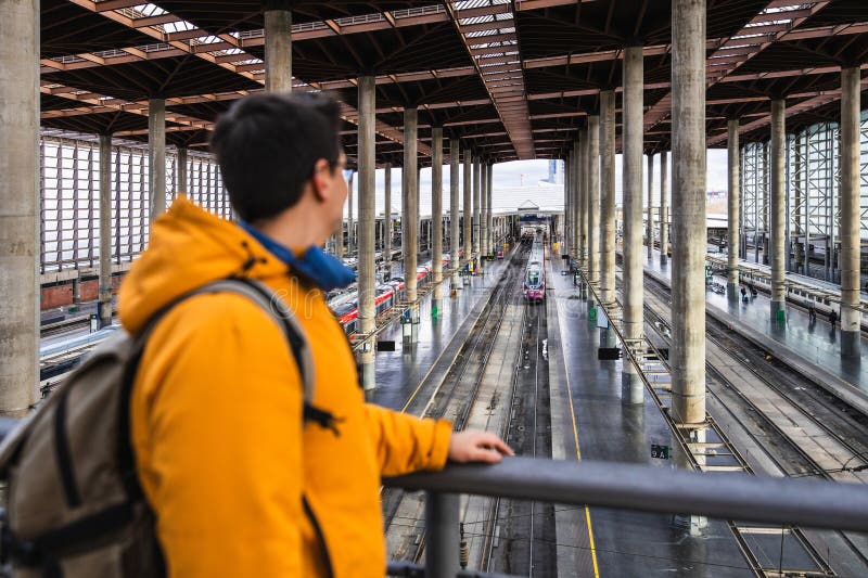 Traveler Contemplating Train Station with Multiple Platforms and Modern ...