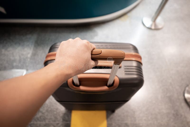 Traveler Hand Holding Suitcase in an Airport. Stock Image - Image of ...