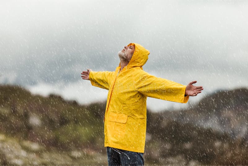 Man in Yellow Raincoat in the Clouds Mountains in Stormy Weather with ...