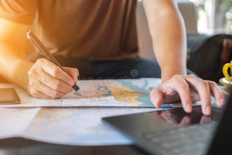 Traveler is Planning Vacation Using the World Map. Man is Writing Notes ...