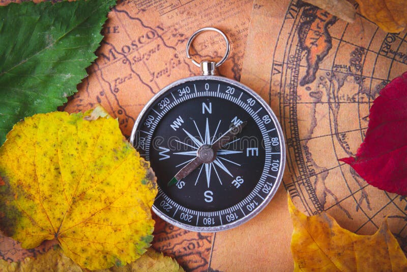 Traveler& X27;s Compass on Map in Bright Multi-colored Autumn Leaves ...