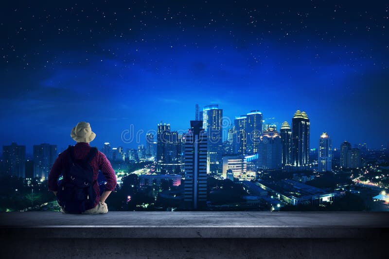Traveler Sitting on the Rooftop Watching City at Night Stock Photo ...