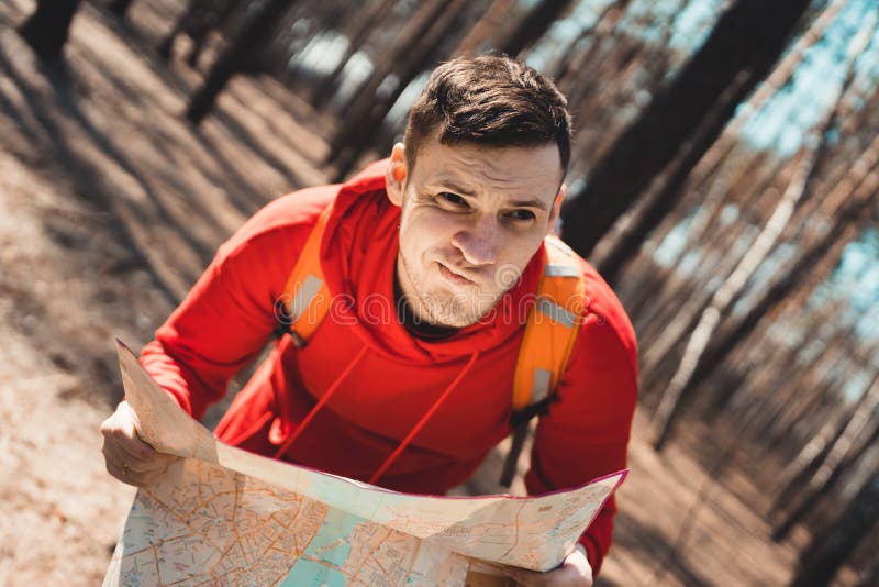 Traveling Man with Map in Woods. Side View of Man with Backpack Reading ...