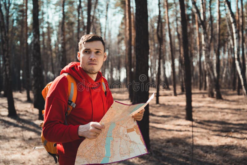 Traveling Man with Map in Woods. Side View of Man with Backpack Reading ...
