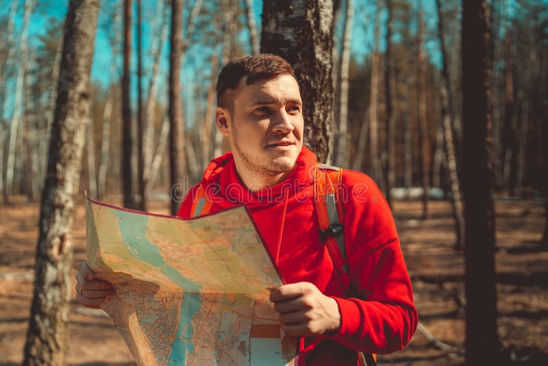 Traveling Man with Map in Woods. Side View of Man with Backpack Reading ...