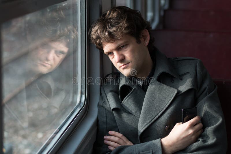 Traveling by Train. Sad Man Traveling by Train, Looking through the ...
