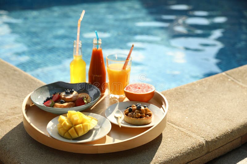 Tray with Delicious Breakfast Near Swimming Pool Stock Photo - Image of ...