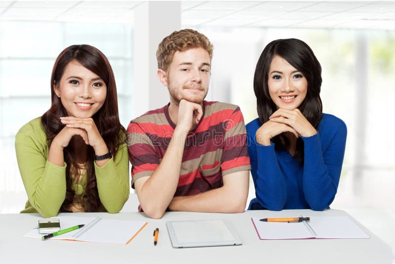 Tre Studenti Sorridenti Che Studiano Insieme Immagine Stock - Immagine ...