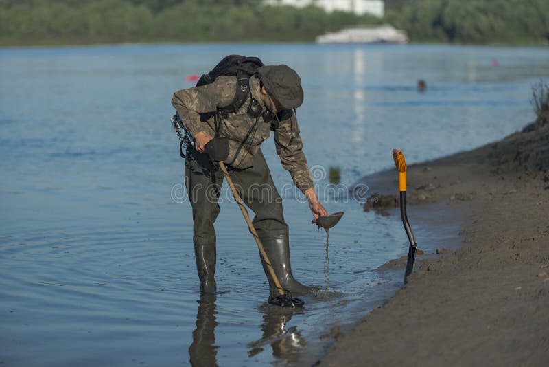 Treasure Hunter is Looking for a Metal Detector in the River Stock ...