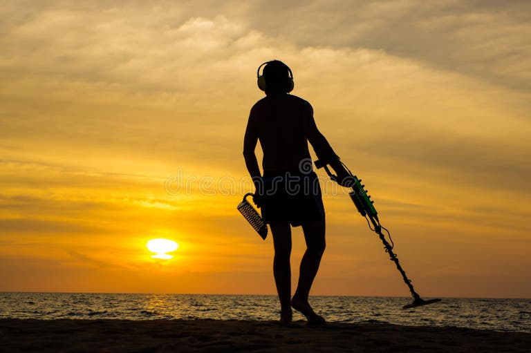 Treasure Hunter with Metal Detector on the Sunset the Beach Stock Image ...