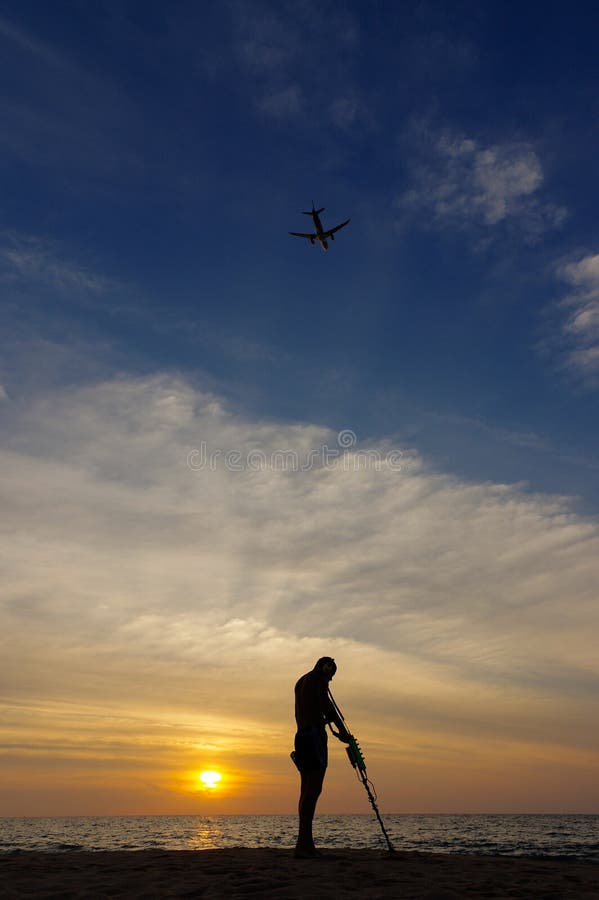 Treasure Hunter with Metal Detector on the Sunset the Beach, a Plan in ...