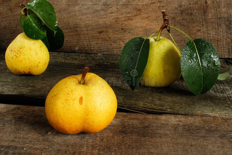 Three Pears with Leaves on a Wooden Surface Stock Photo - Image of ...