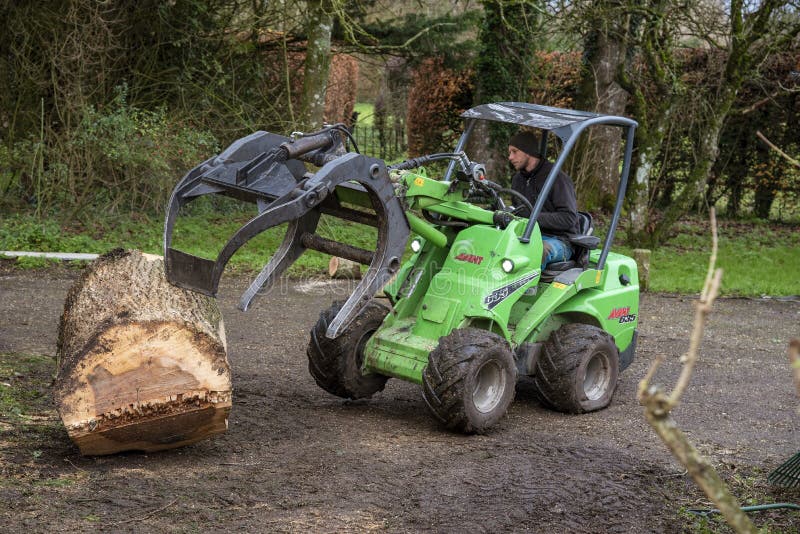 Tree Trunk Being Moved Using a Small Tractor and Grab Editorial Photo ...