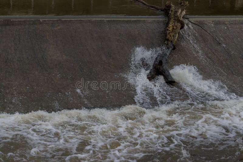 Tree Trunk on a Weir and Water Splashing Over it Stock Photo - Image of ...