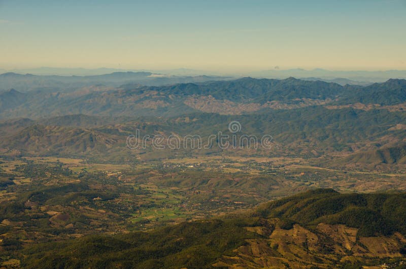 Treeless Mountain Crest with Dirt Road Against Distant Mountain Ridges ...