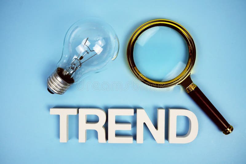 Trend Word with Light Bulb and Magnifying Glass Top View on Blue ...