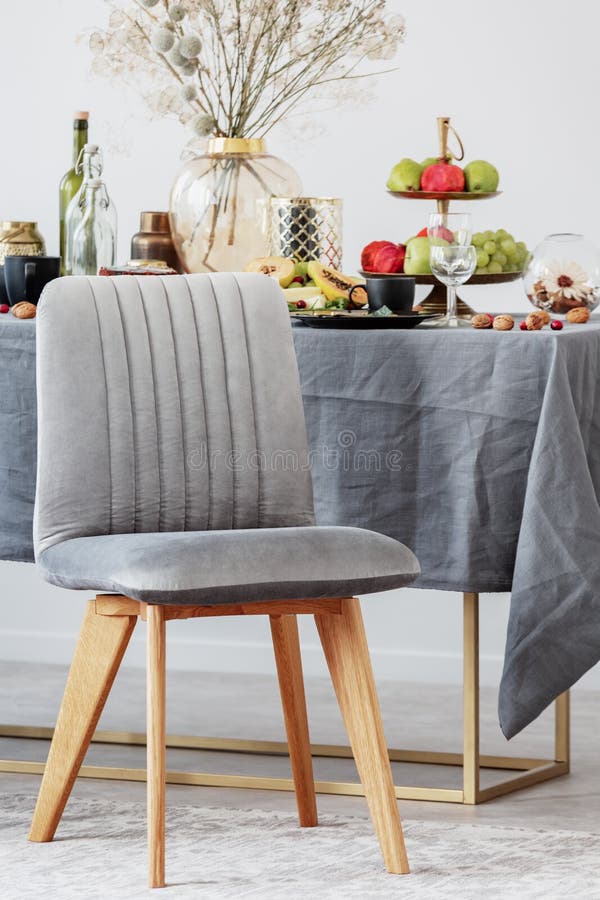 Trendy Grey Chair in Front of Dining Room Table Full of Food Stock ...