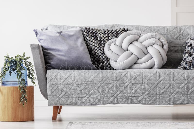 Trendy Knot Light Grey Pillow on Comfortable Scandinavian Couch Stock ...
