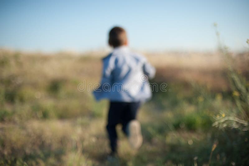 Trendy Little Boy Running among the Grass in a Blurred Focus Stock ...