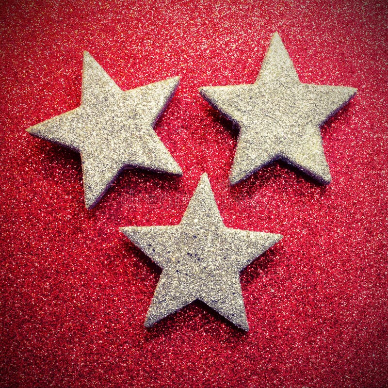 Tres Estrellas De Plata En Textura Reluciente Roja Imagen de archivo ...