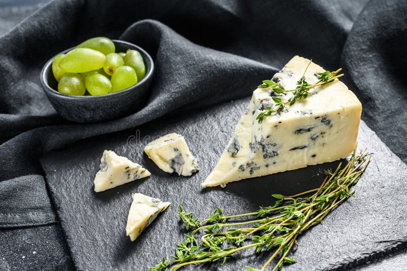 Triangle of Blue Cheese with Grapes on Cutting Board. Black Background ...