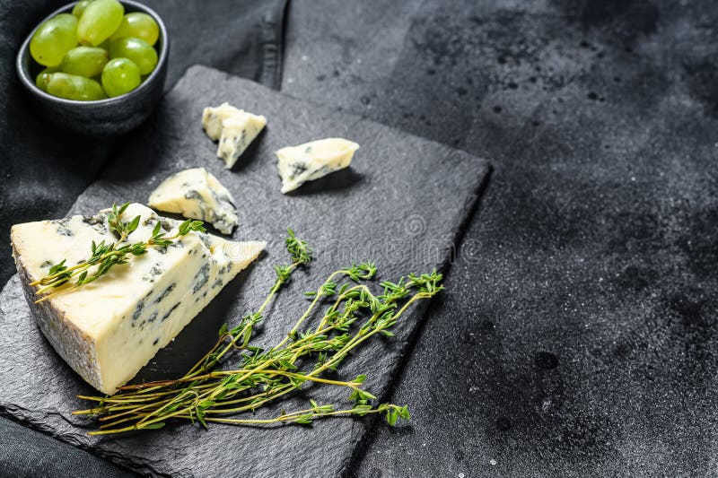 Triangle of Blue Cheese with Grapes on Cutting Board. Black Background ...