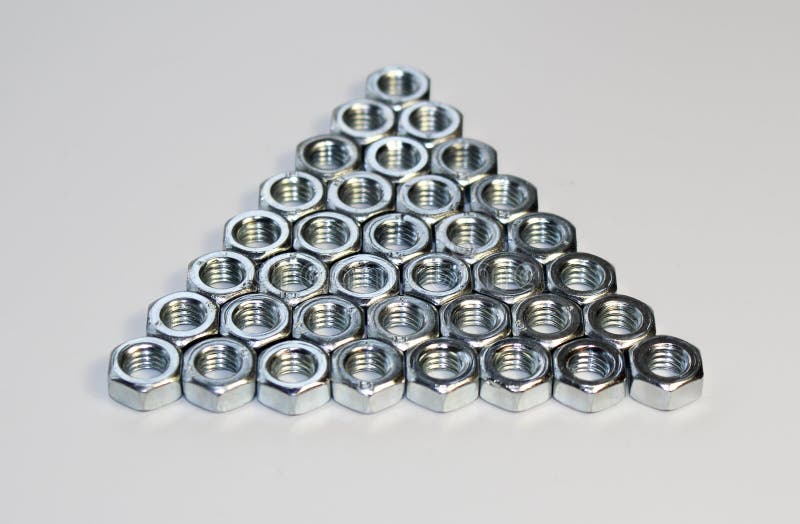 Triangle of metal nuts stock photo. Image of manufacturing - 99434798