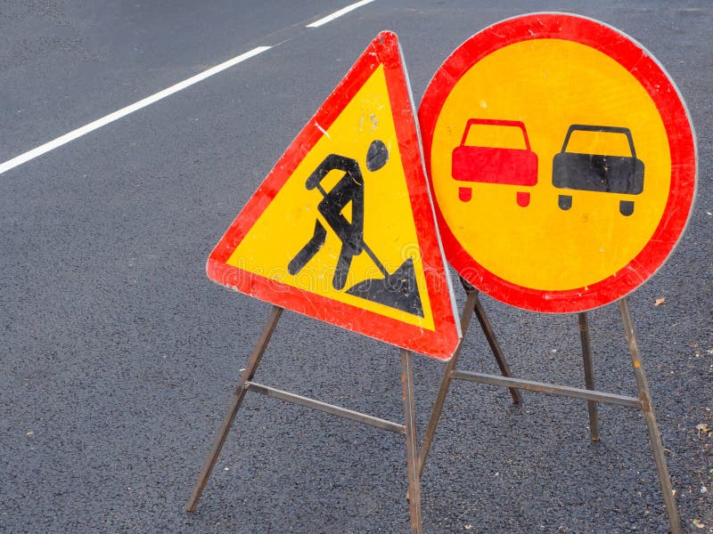 Triangular and Circular Road Signs Stand on a Freshly Asphalted Road ...