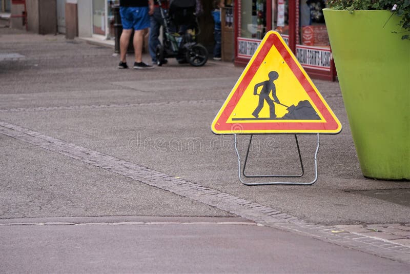 Triangular Men at Work Sign Stands on Sidewalk Stock Photo - Image of ...